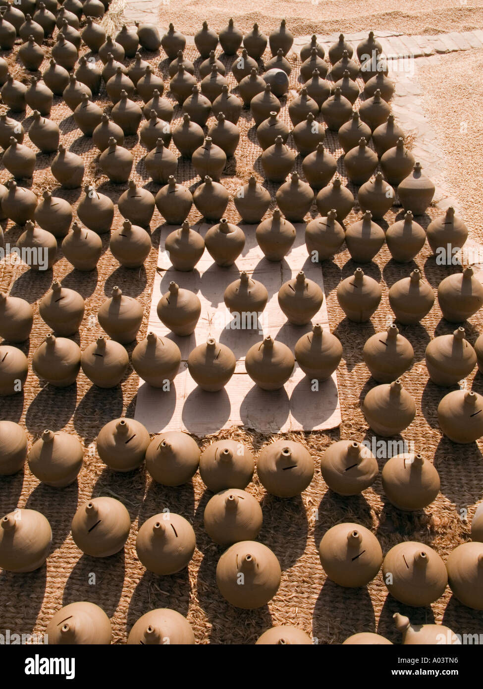 ROWS of CLAY POTS spread out on mats to dry in sun Potter's Square ...