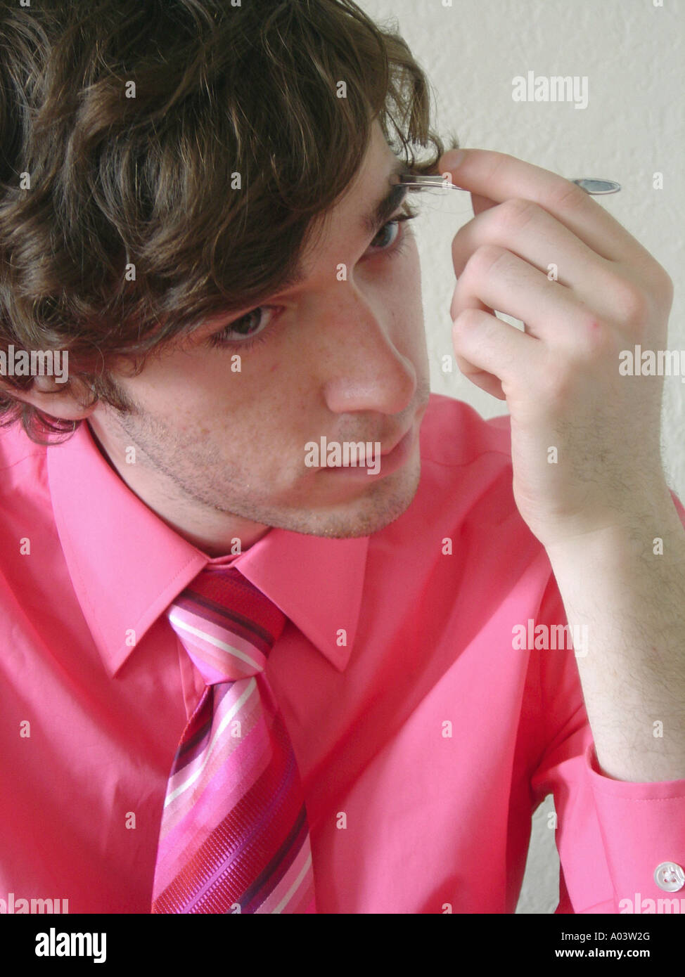 Young Man Plucking His Eyebrows He is Wearing A Pink Shirt and a Pink ...