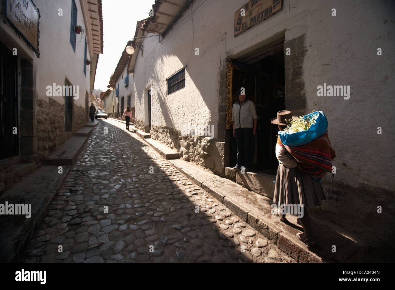 Indigenous woman walking up street in Cusco Peru Stock Photo - Alamy