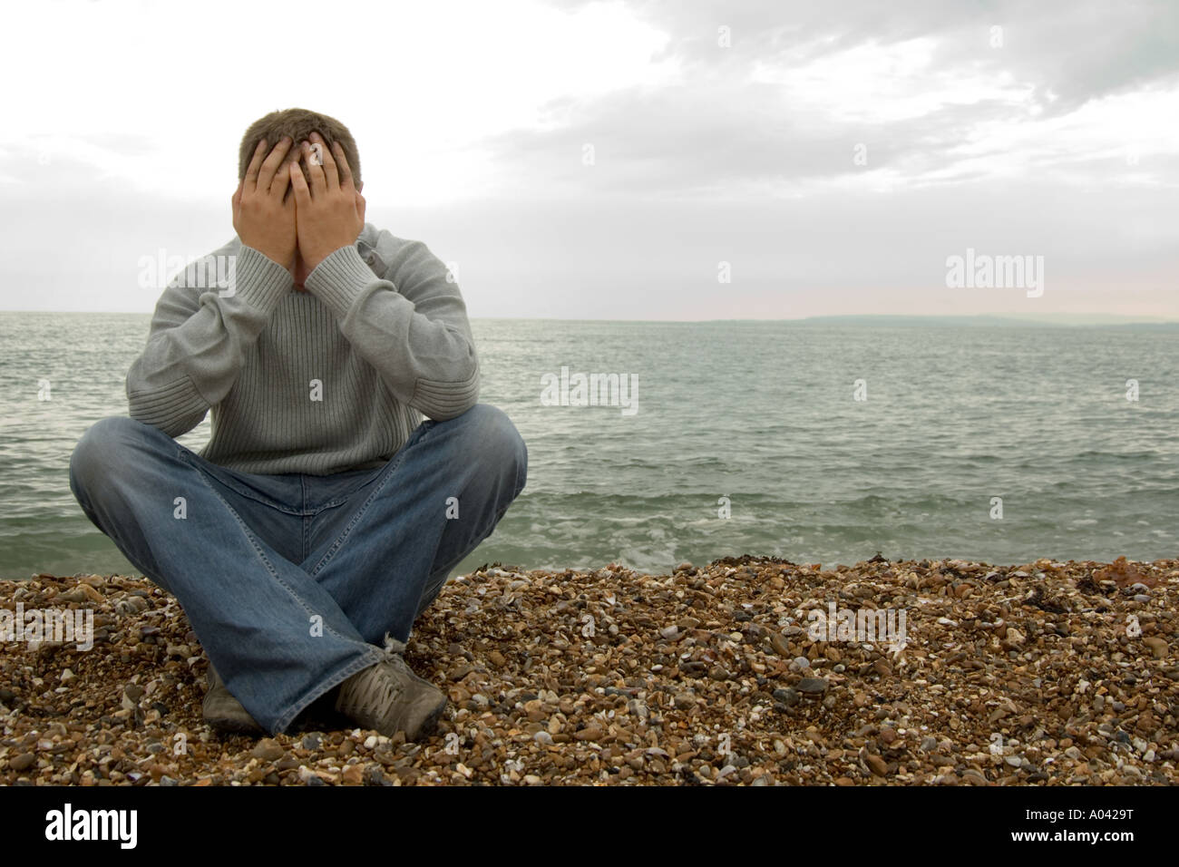 Young man with head in hands hi-res stock photography and images - Alamy
