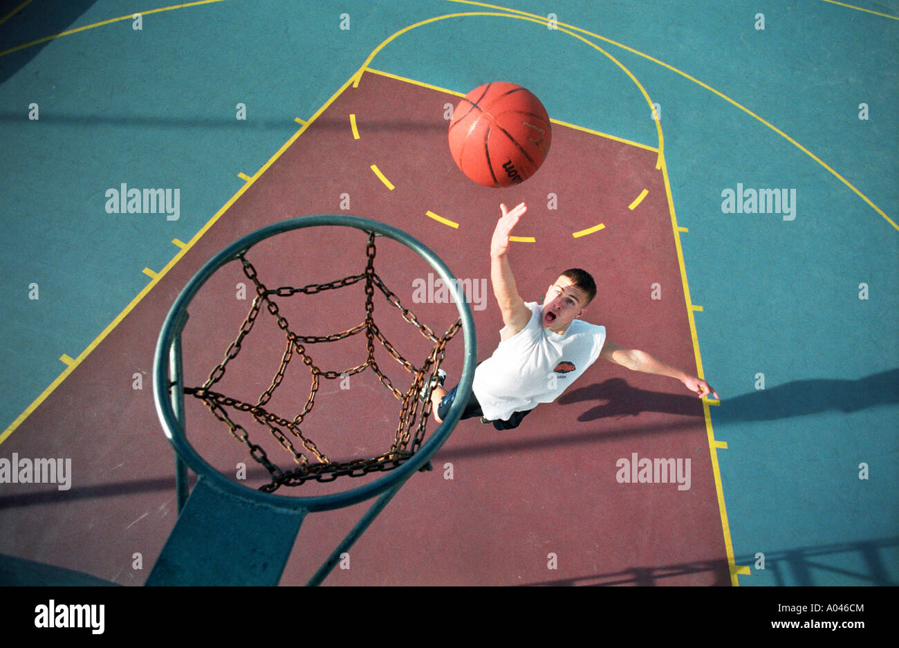 Boy throwing basketball into hoop Stock Photo - Alamy