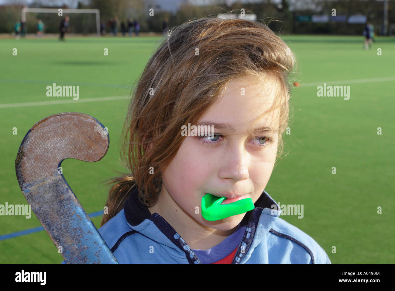 Young girl hockey player tired after hockey match with stick and gum ...