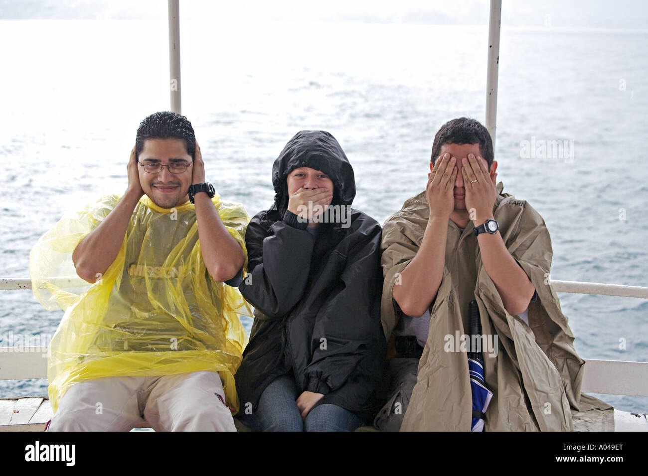 GUATEMALA LAKE ATITLAN Three monkeys on a boat Three Hispanic young ...