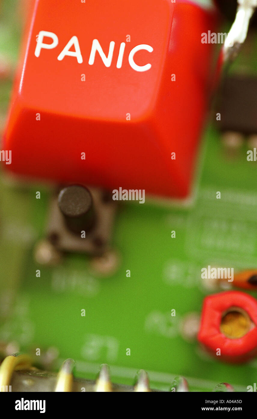 Close up of a red 'panic' button on a green circuit board background ...