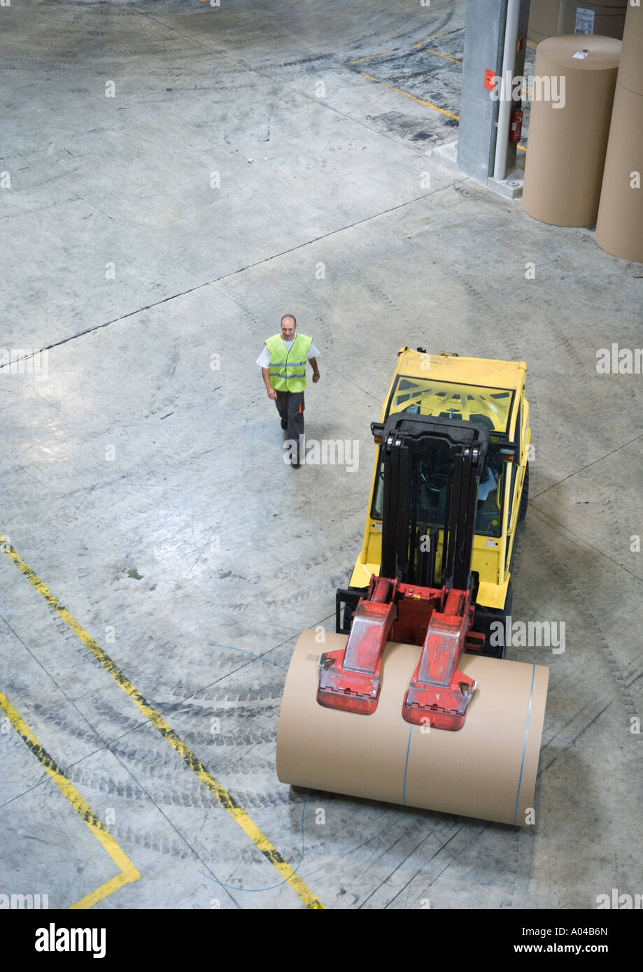 Fork lift picking up roll of paper Stock Photo - Alamy