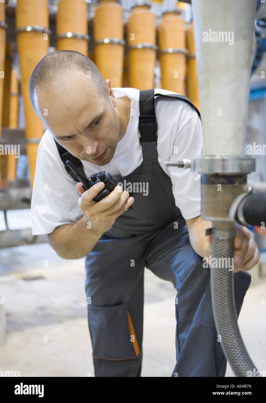 Factory worker using walkie talkie Stock Photo - Alamy