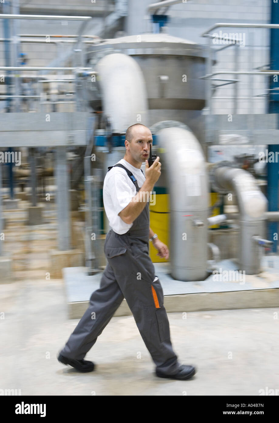 Factory worker using walkie talkie Stock Photo - Alamy