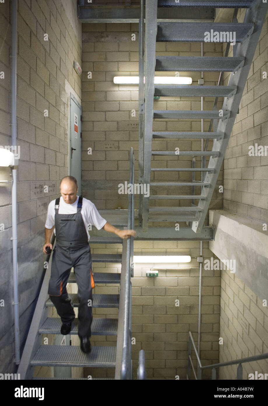 Factory worker walking down stairs Stock Photo - Alamy