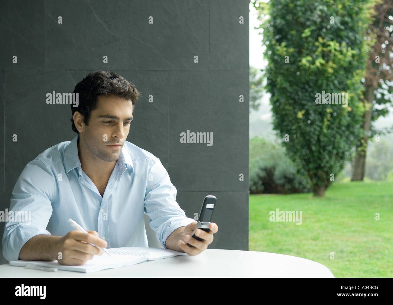 Businessman sitting wall using cell phone hi-res stock photography and images - Alamy