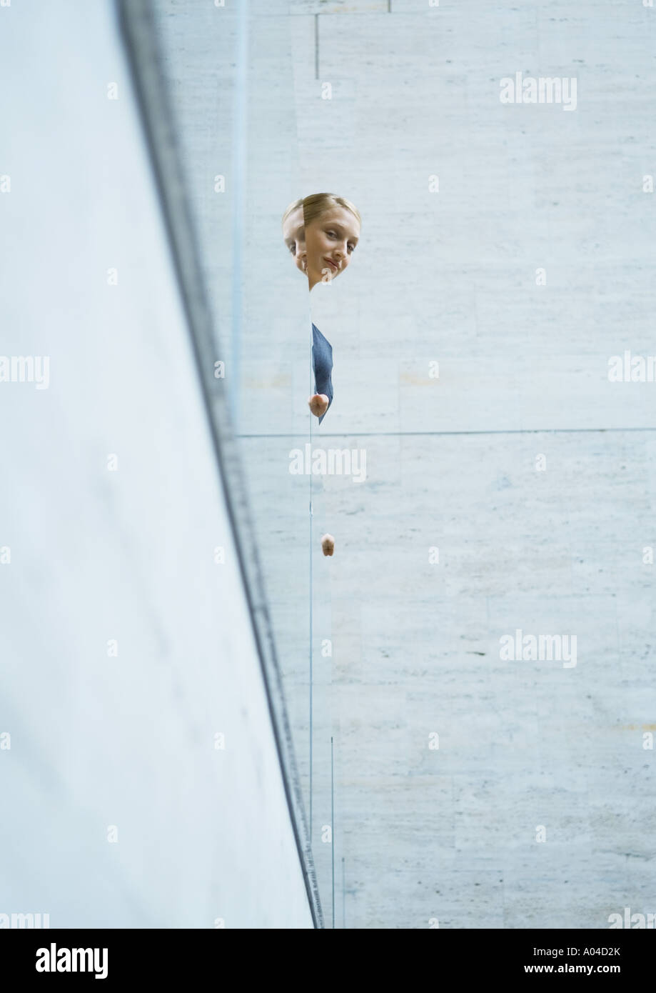 Woman looking over edge of balcony Stock Photo - Alamy