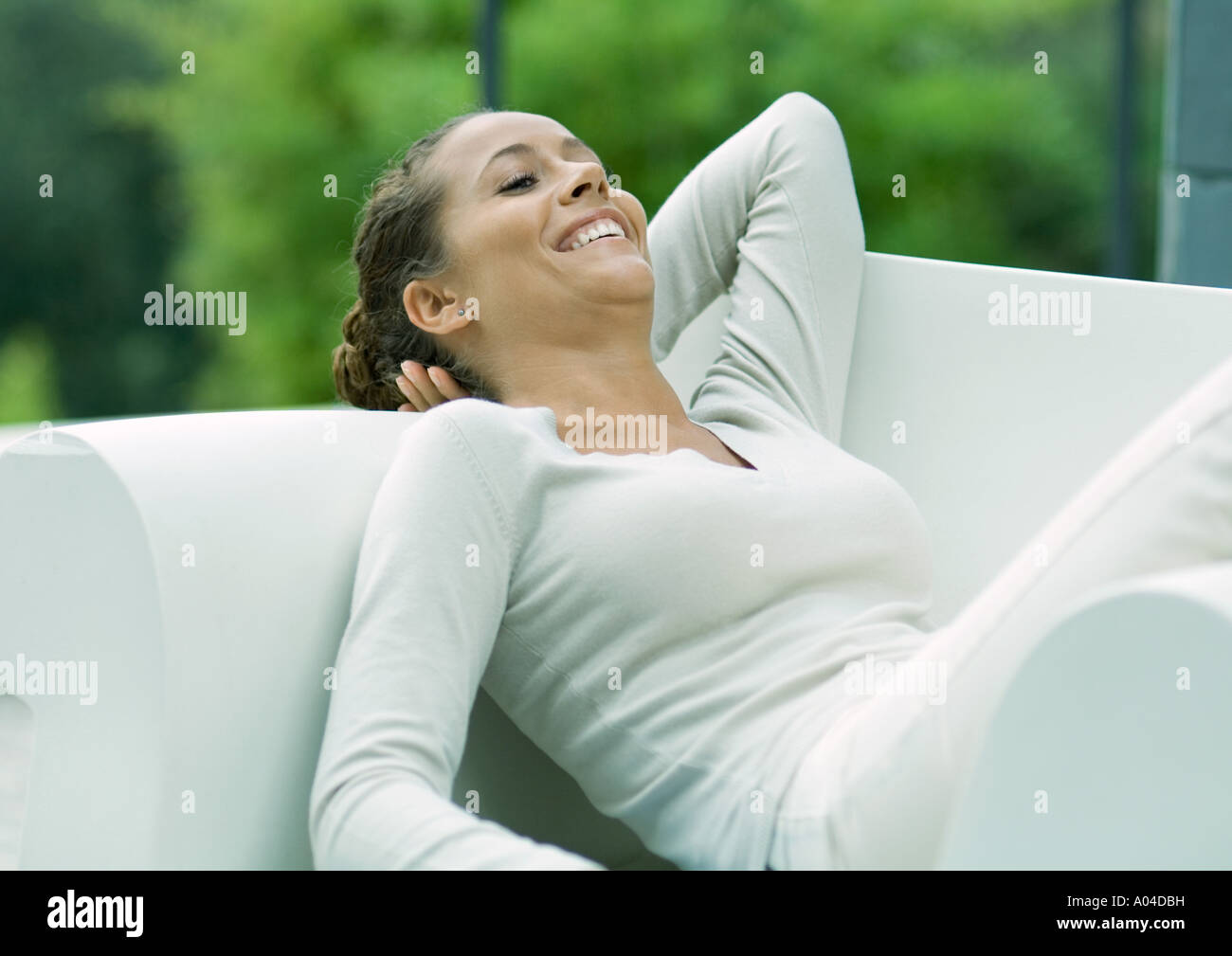 Woman lounging in armchair Stock Photo - Alamy
