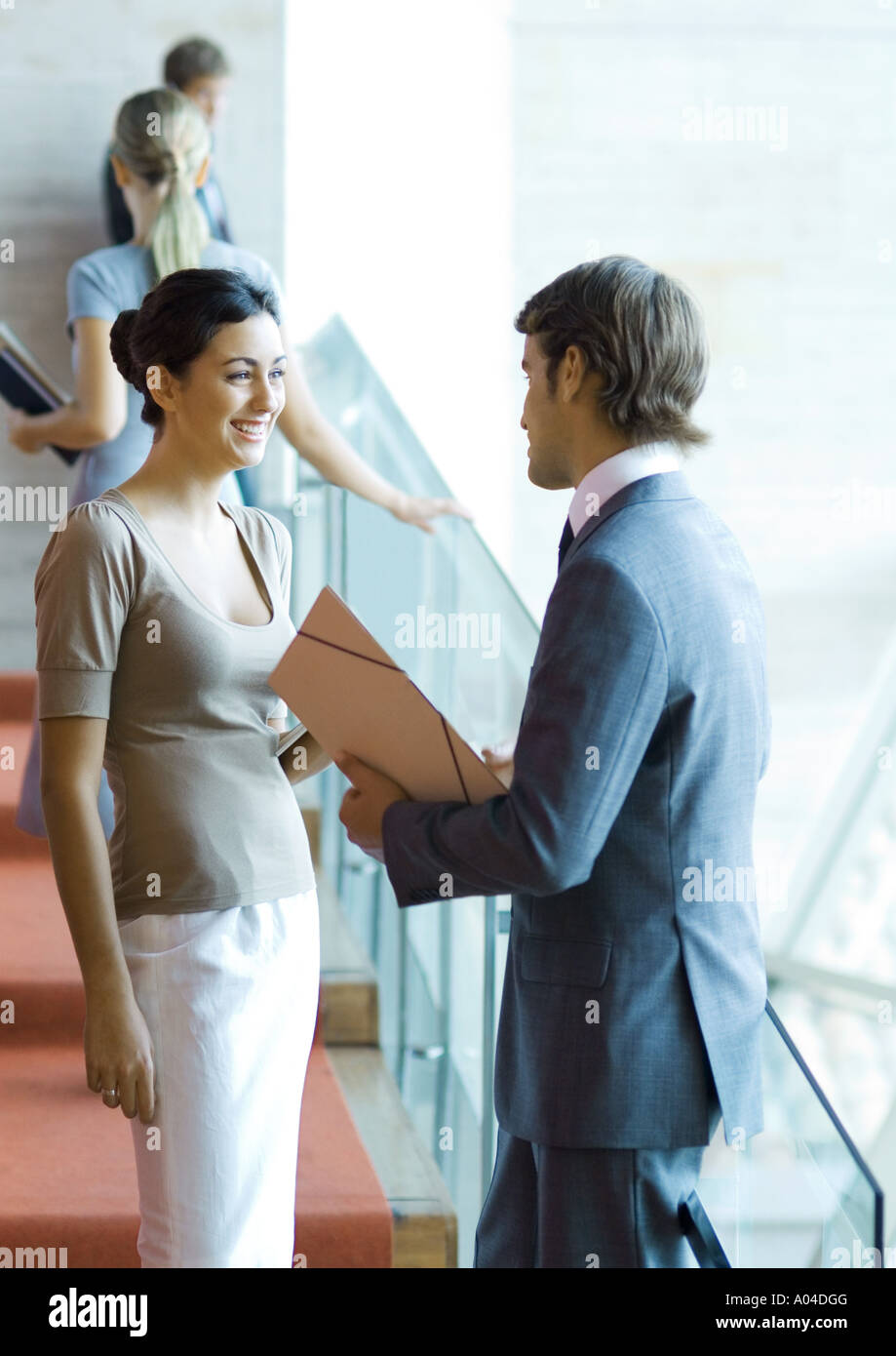 Executives standing, speaking Stock Photo - Alamy