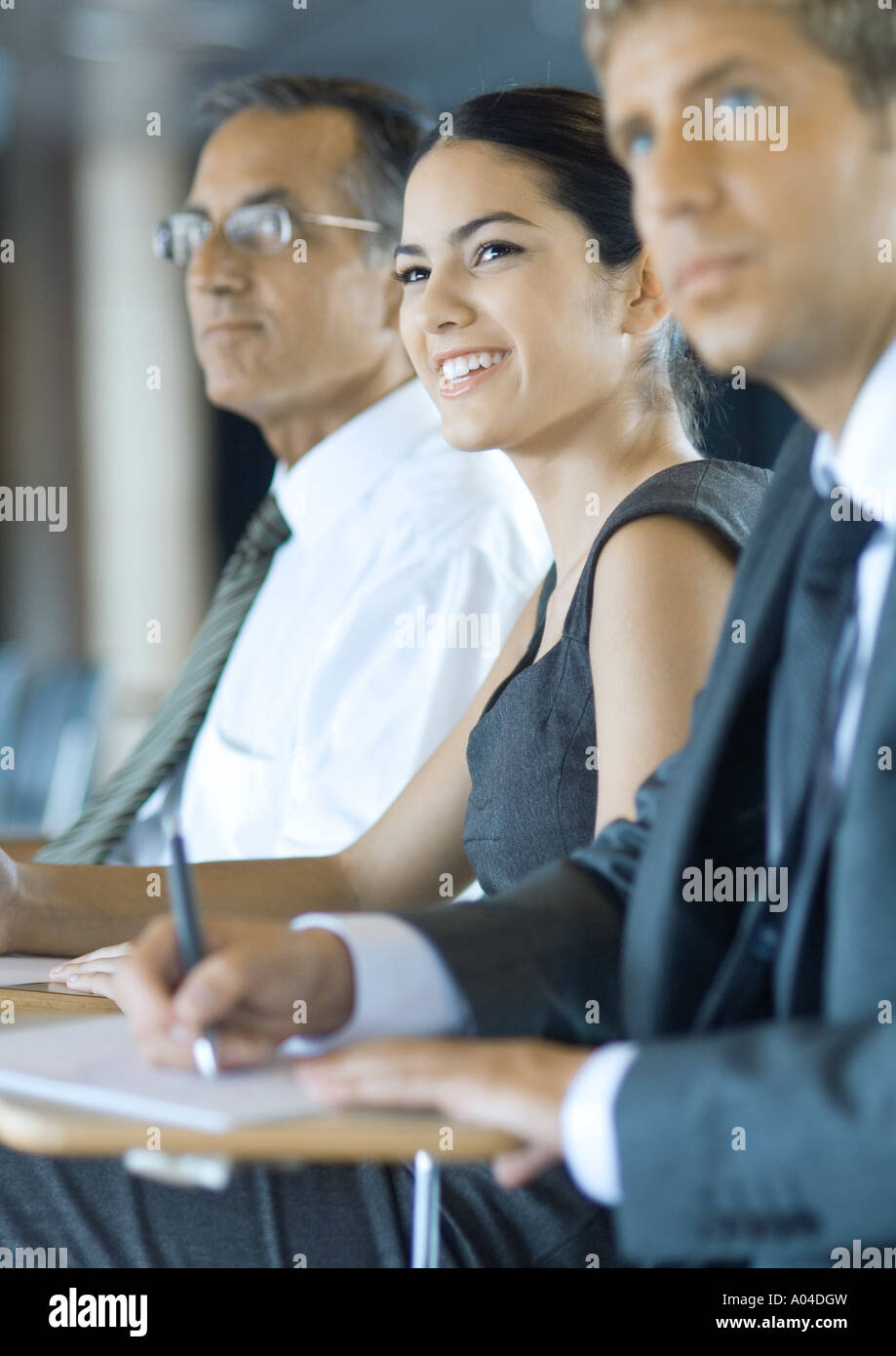 Executives sitting, taking notes Stock Photo - Alamy