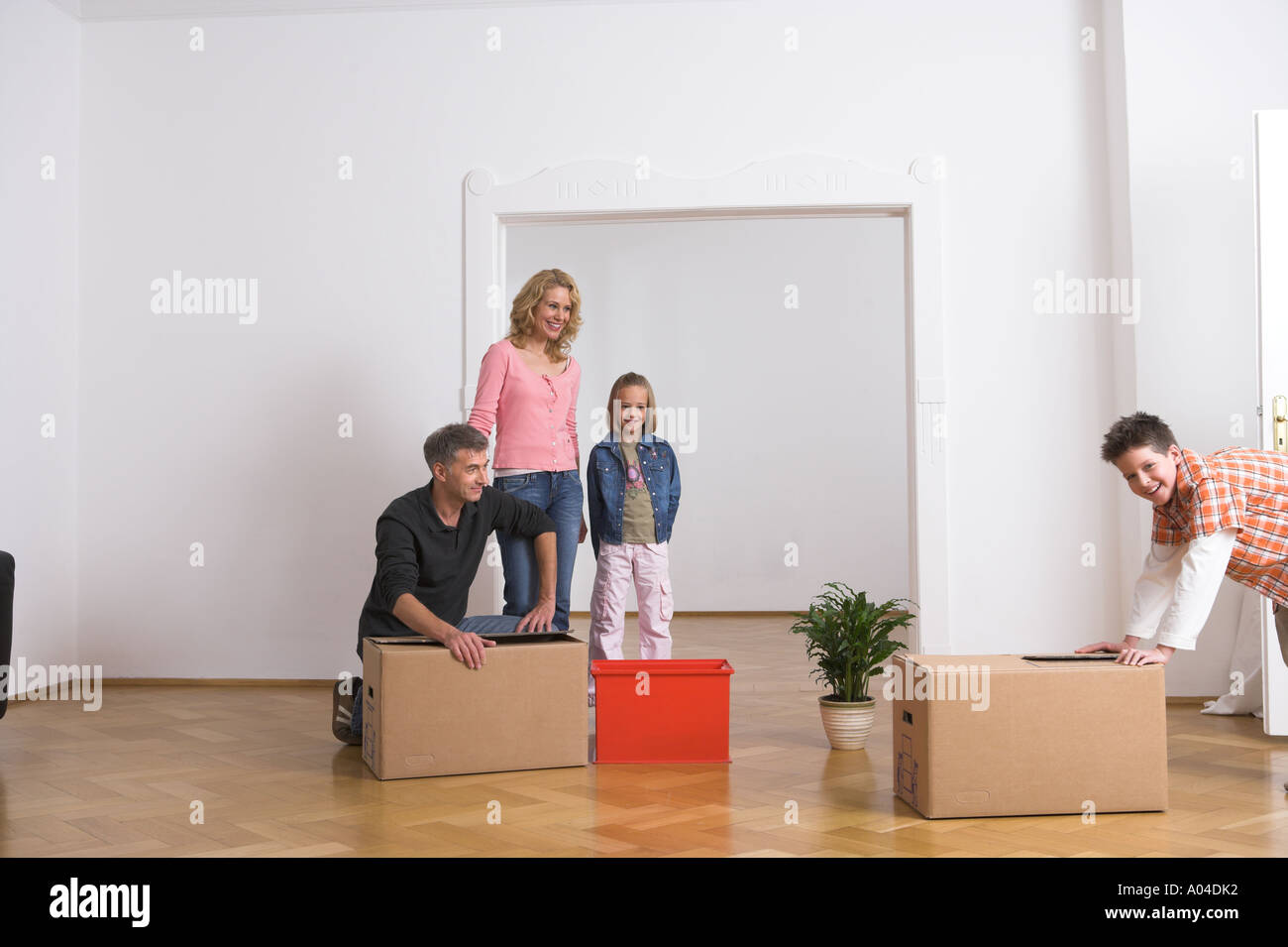 family packing moving boxes while moving home Stock Photo - Alamy