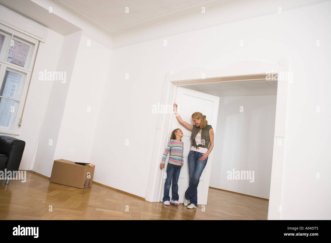mother and daughter standing in the door of empty room in new home ...