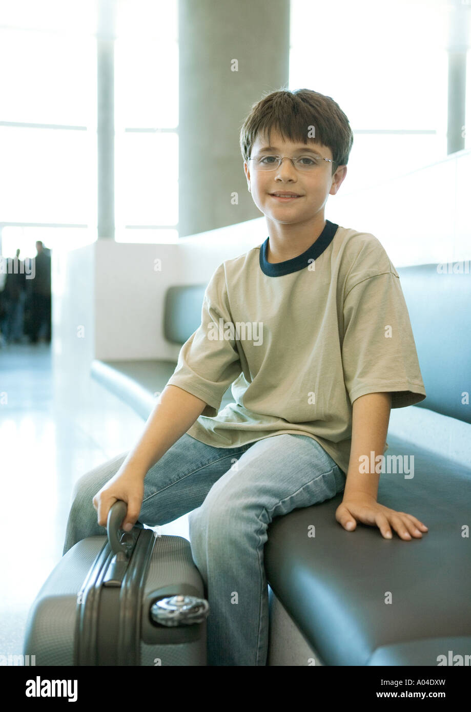 Boy with suitcase sitting in airport Stock Photo - Alamy