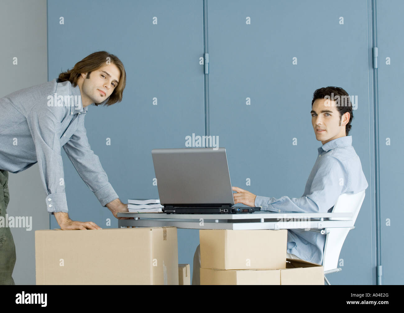 Businessmen working at table top supported by cardboard boxes Stock ...