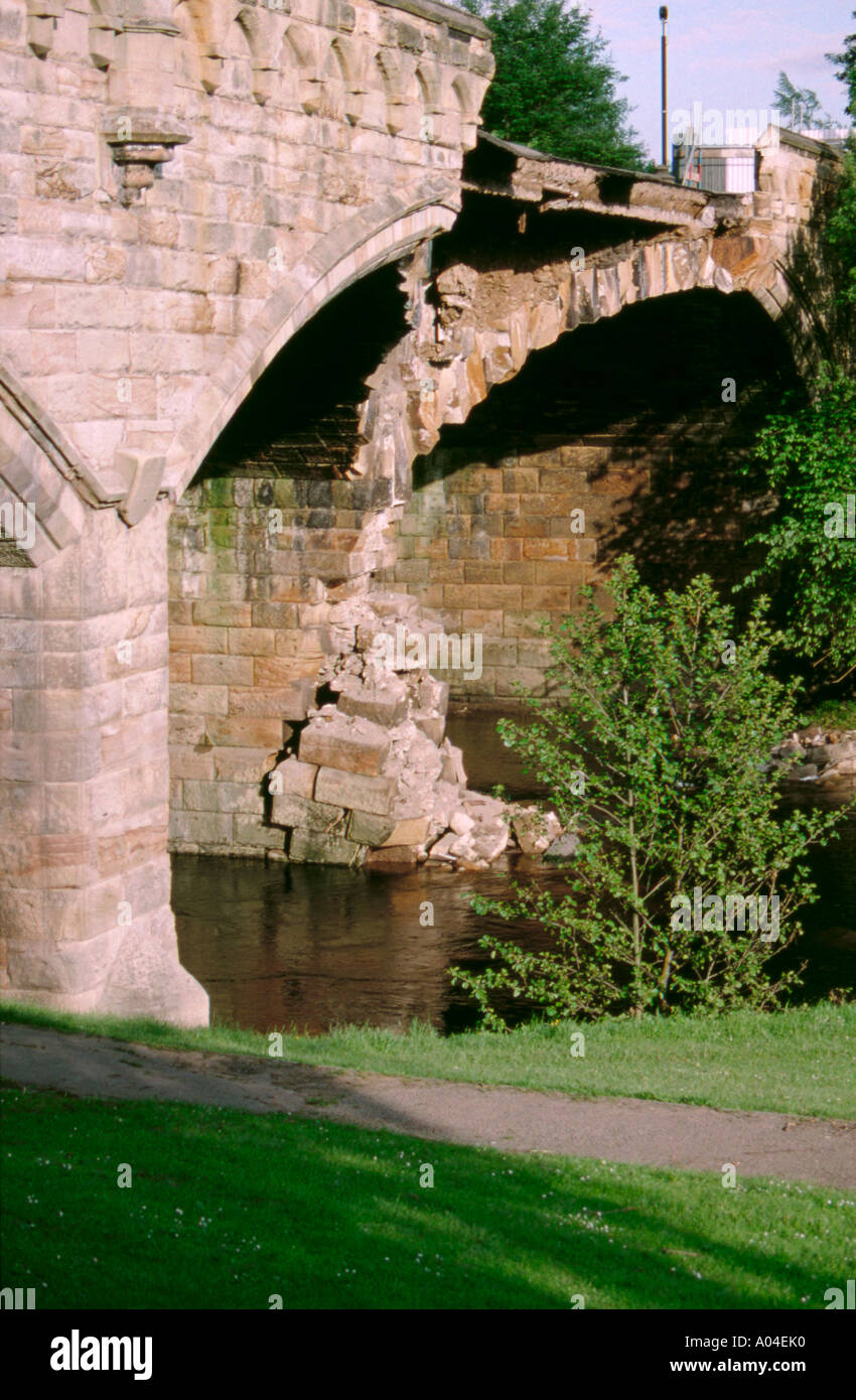 Flood damaged partially collapsed old stone masonry bridge over the ...