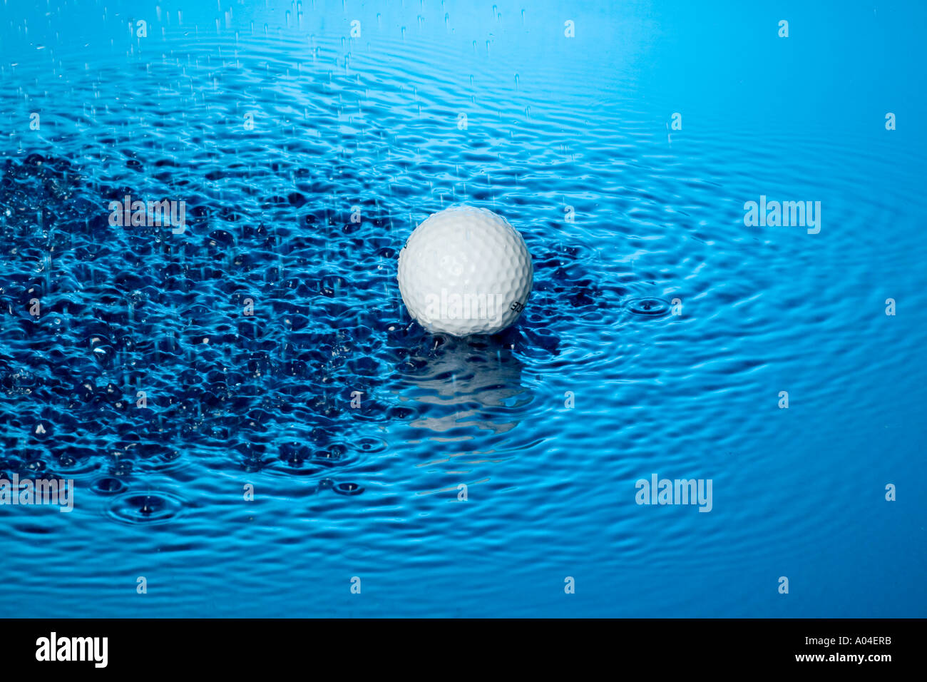 Golf ball splashing into blue water Stock Photo - Alamy