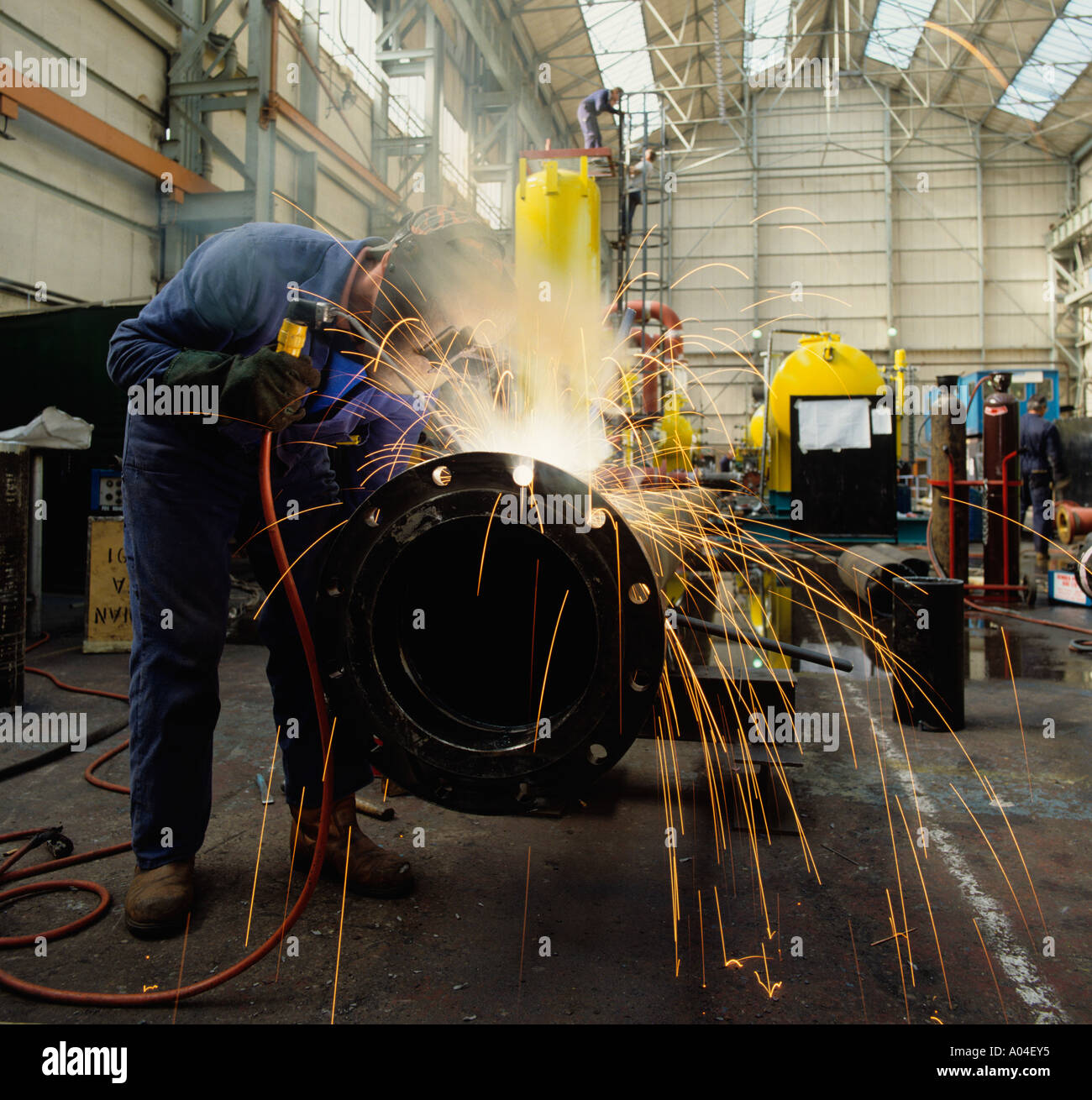 Industry man welding pipe Stock Photo - Alamy