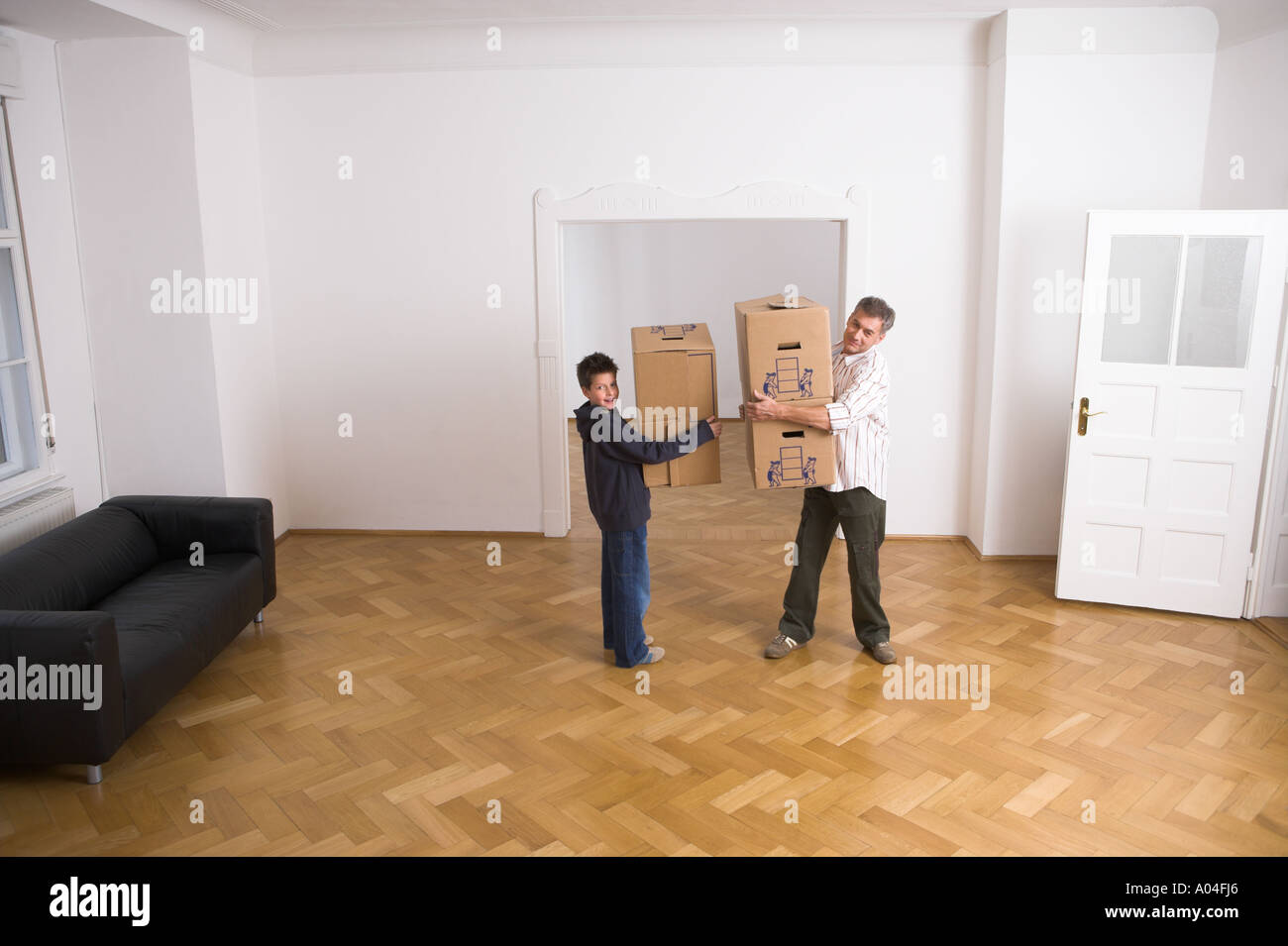 boy and man carrying moving boxes in new apartment Stock Photo - Alamy