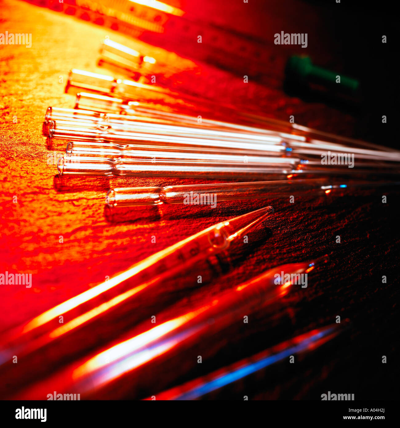Group of Pipettes with Red and Yellow Light on Black Slate Background ...
