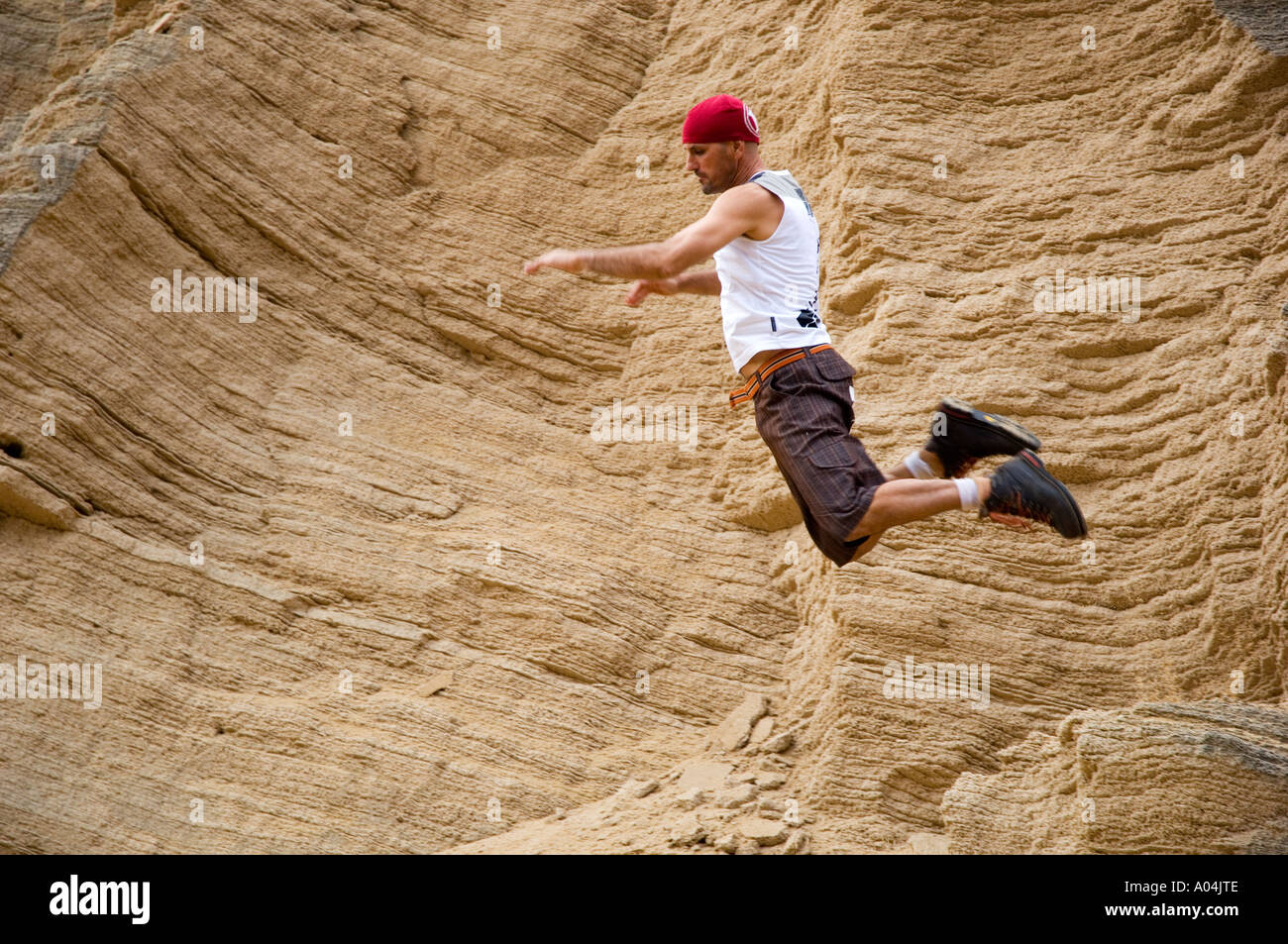 Full length shot of a man falling; background is of a well-defined ...