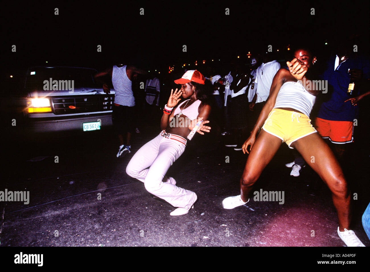 Girls dancing in front of a car in the street at Passa Passa Kingston ...