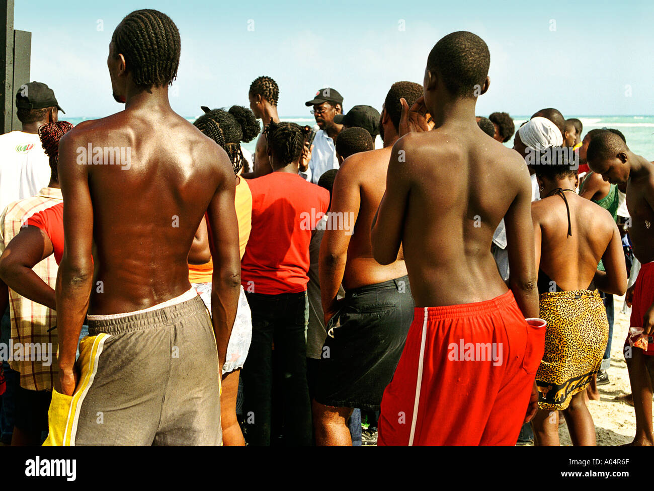 Two boys backs in a crowd on Hellshire Beach Jamaica Stock Photo - Alamy