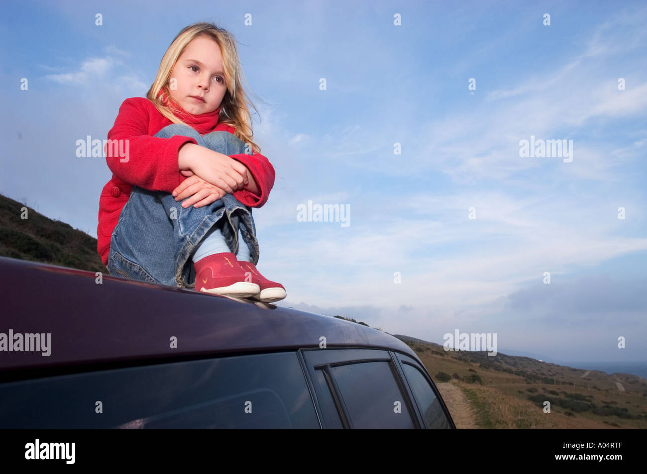 Young child sitting on top of a car Stock Photo - Alamy