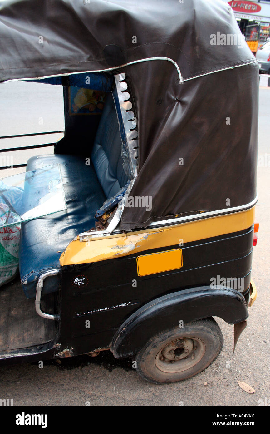 Rear view of wrecked auto rickshaw, with a piece of glass and luggage ...