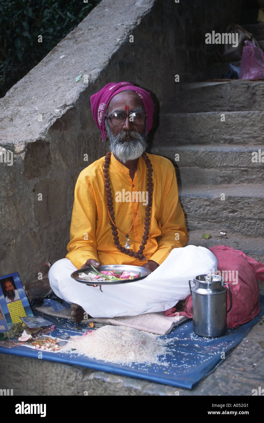 Holy man sitting on on steps with plate near a temple in Kathmandu ...