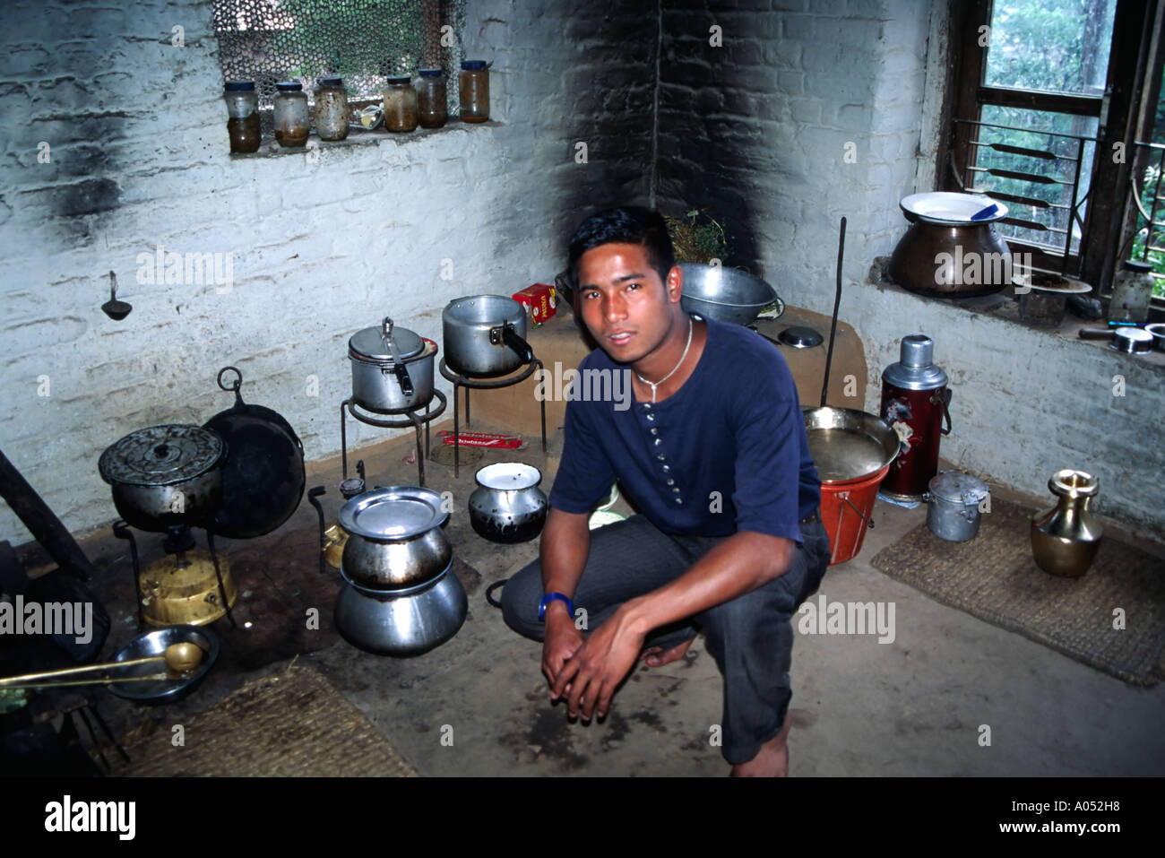 Young man in his traditional nepalese family kitchen in Kathmandu ...