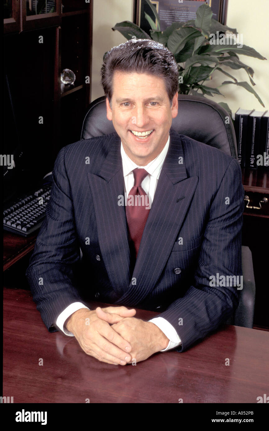 happy businessman at his desk in office in executive chair with happy ...