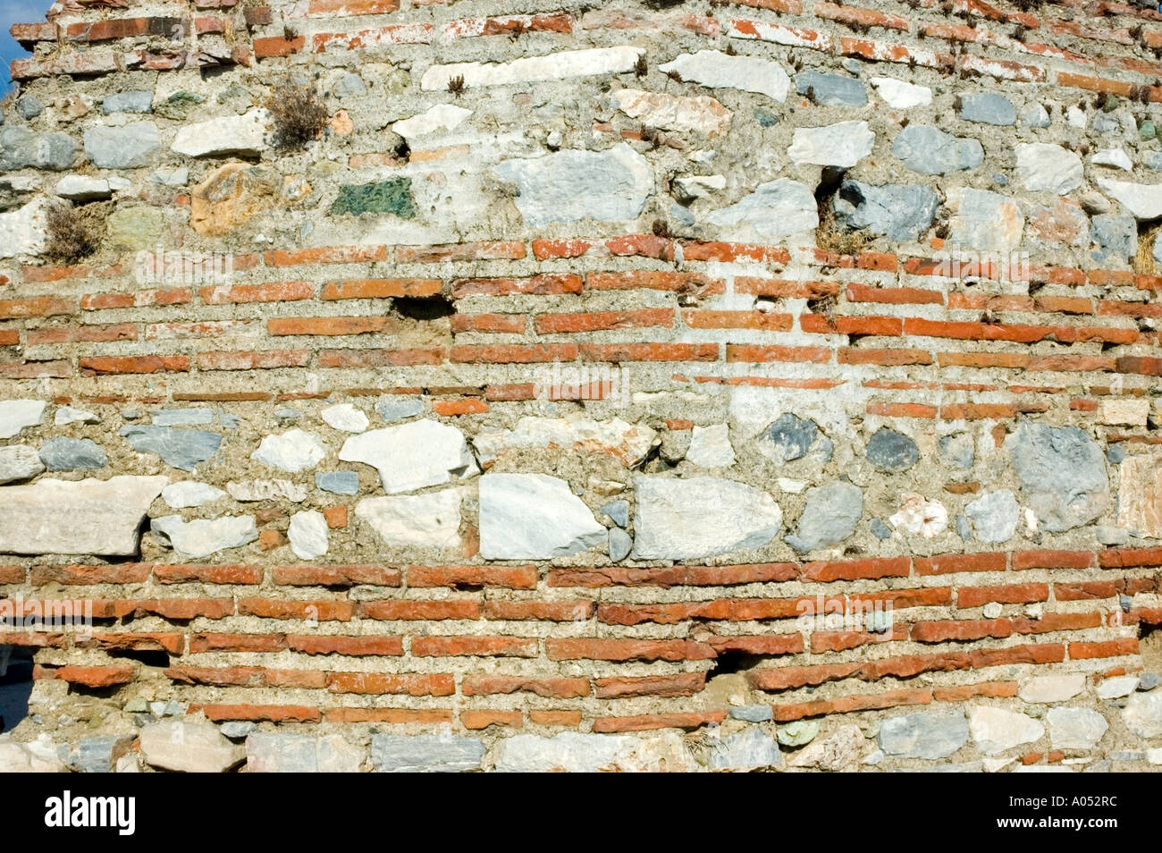 An ancient old rough drystone masonry and terracotta brick wall, Saint ...