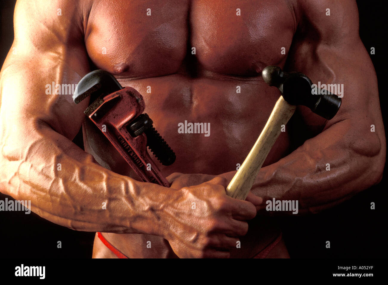 powerful muscular handyman with tools ready for work as a plumber or ...