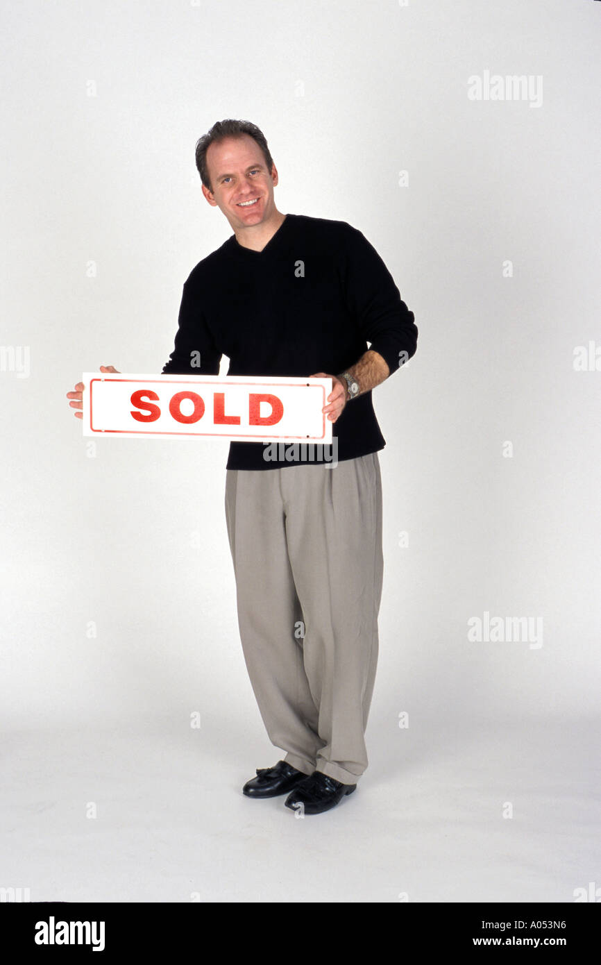successful salesman holding a sold sign with a happy smiling expression ...