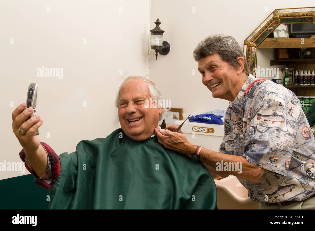 Small town America old fashioned barber shop with customer taking cell ...