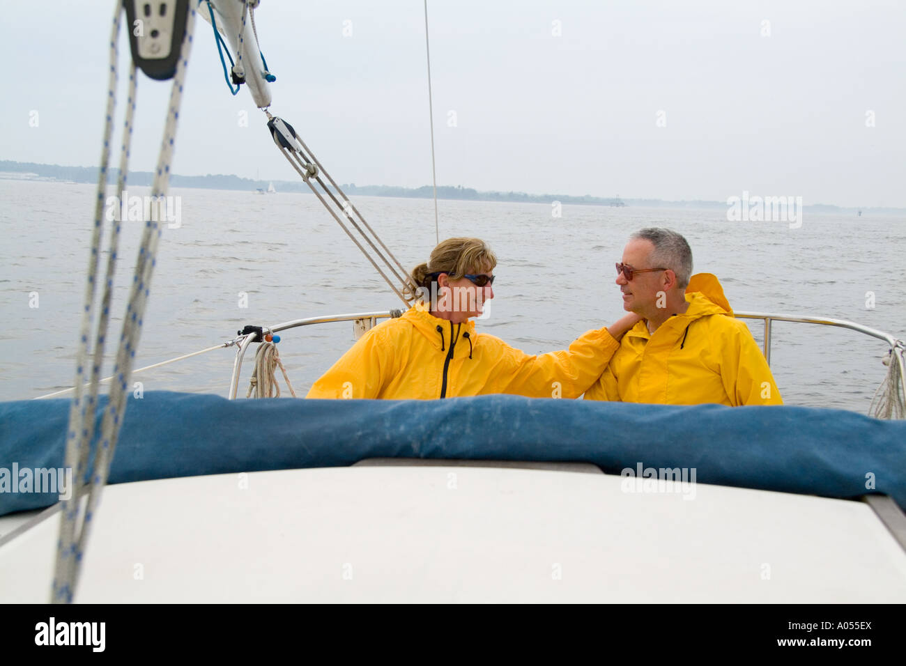 Couple in yellow slickers sailing small sailboat for fun on Chesapeake ...