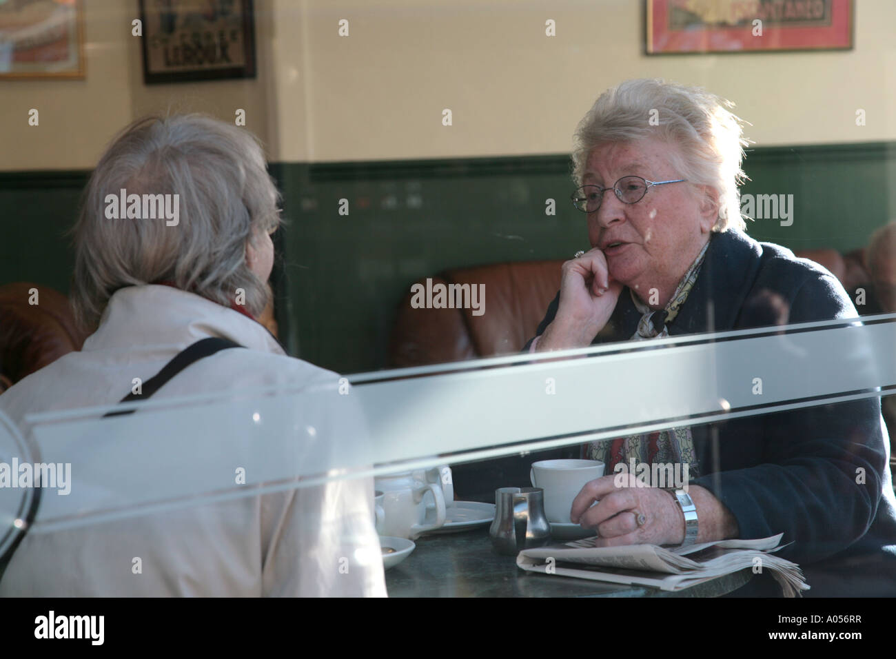 two ladies chatting with cup of tea in cafe Stock Photo - Alamy