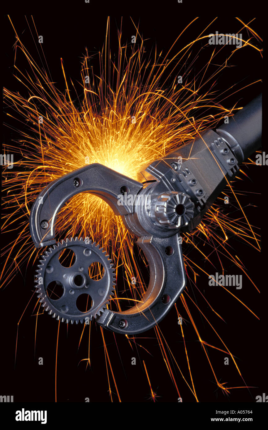 Robot arm holding gear sparking Stock Photo - Alamy