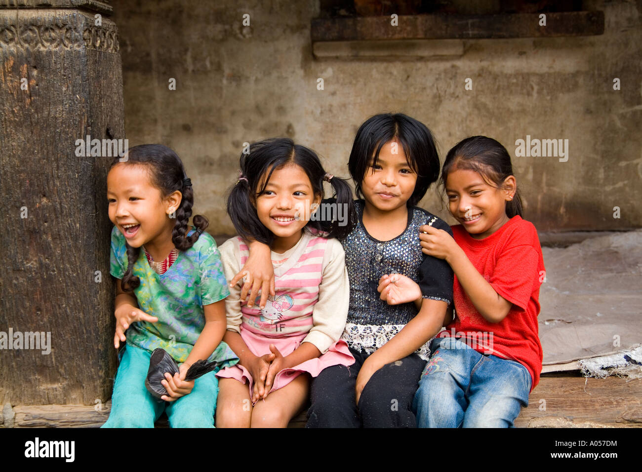 Beautiful young children laughing aged 6 and 7 having fun in village of ...
