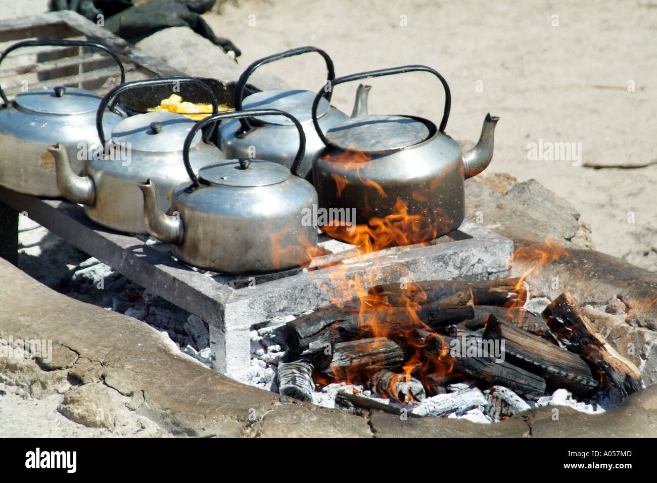 Kettles on the boil over open wood flaming fire Beach restaurant ...