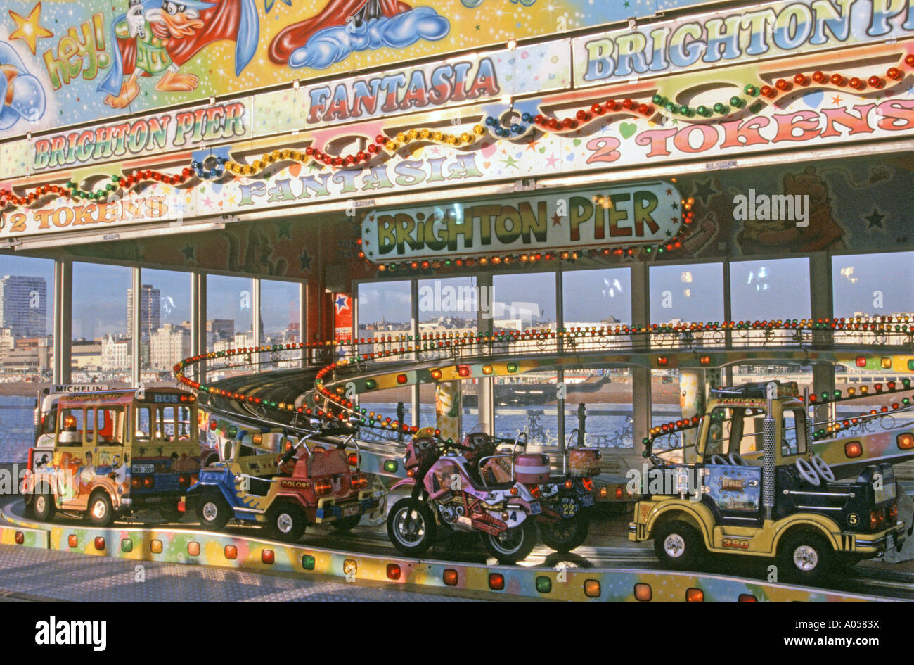 Small fairground ride on Brighton Pier with the city skyline in the ...