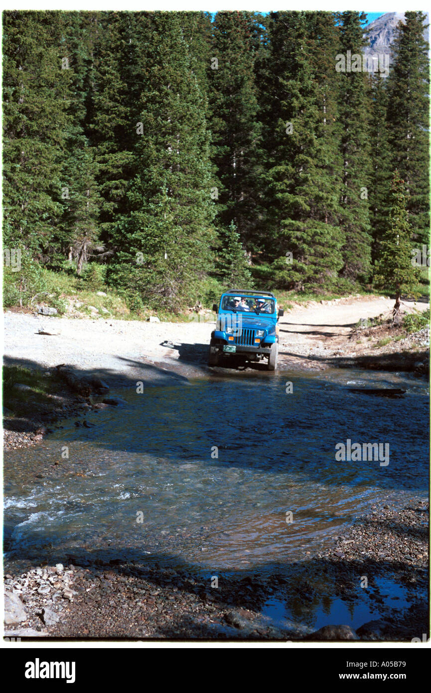Stream crossing by 4 wheel drive vehicle on a dirt road high in the ...