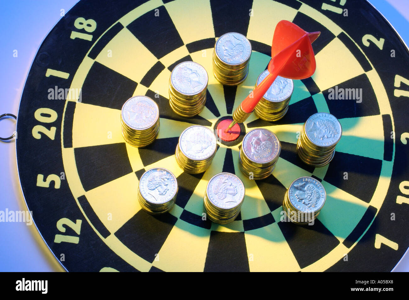 Dart and Stacks of Coins on Dartboard Stock Photo - Alamy