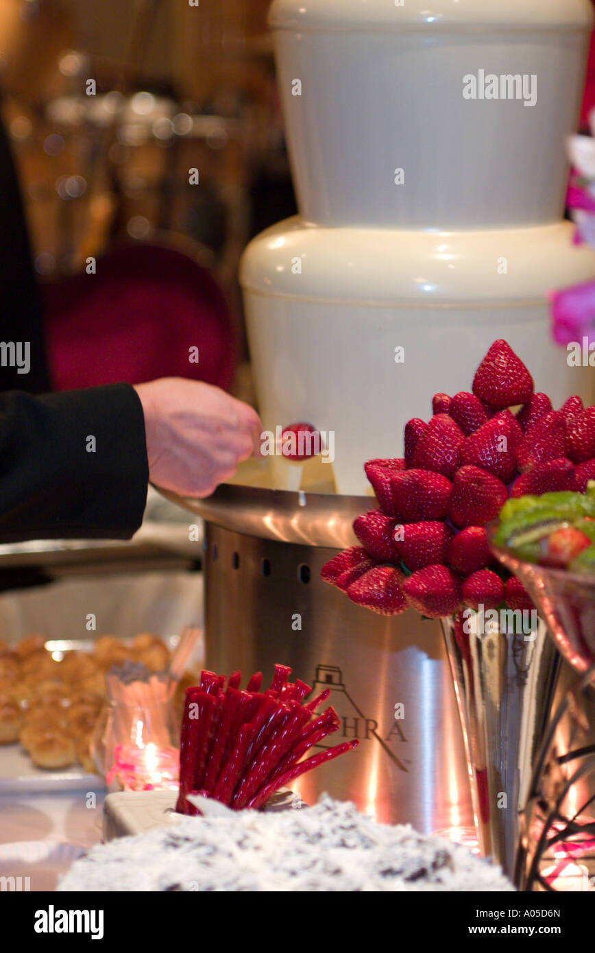 Strawberry dipped in to a white chocolate fountain Stock Photo - Alamy