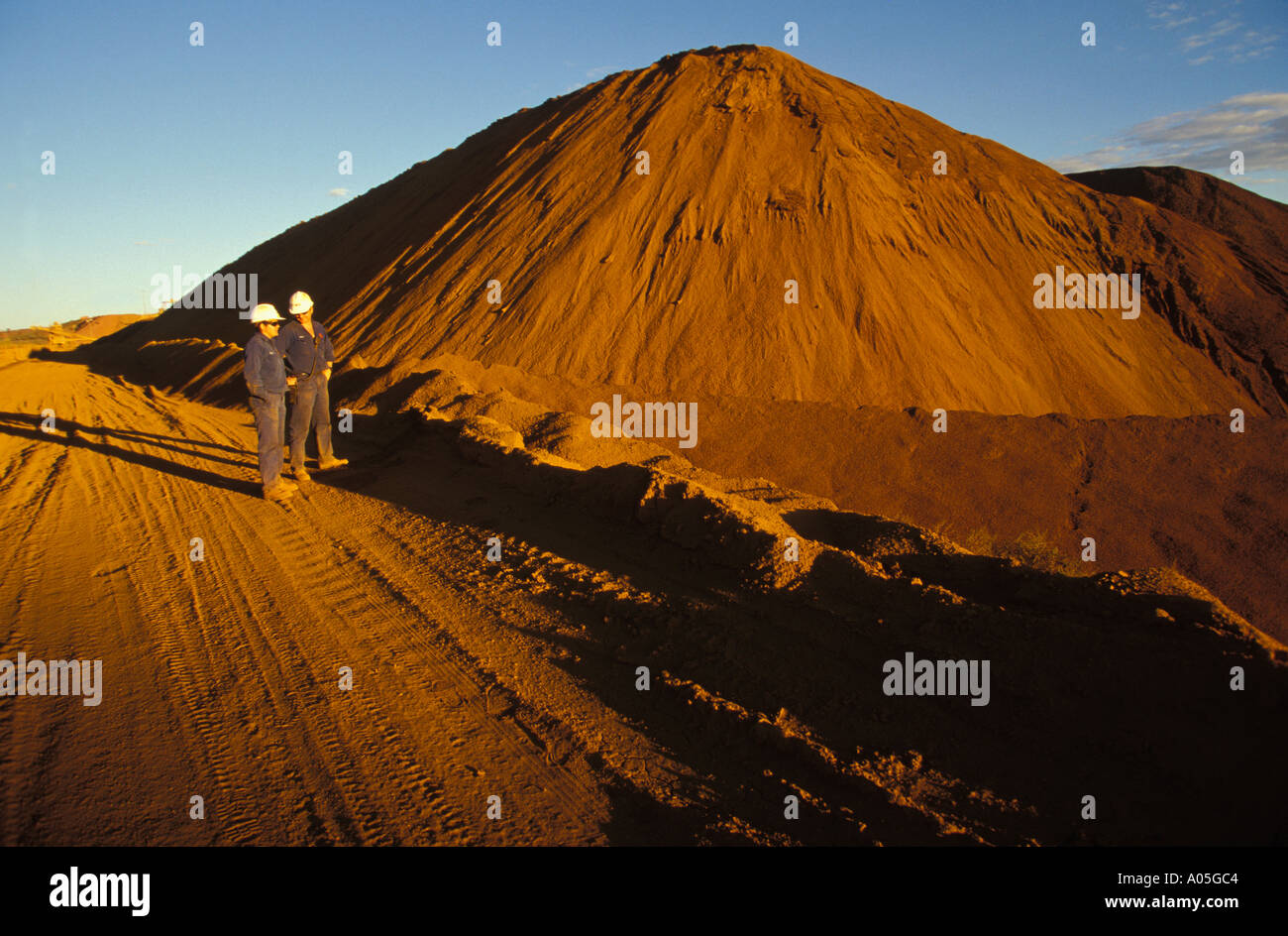 Two miners beside slag heap at Hammersley iron ore mine near Pilbarra ...