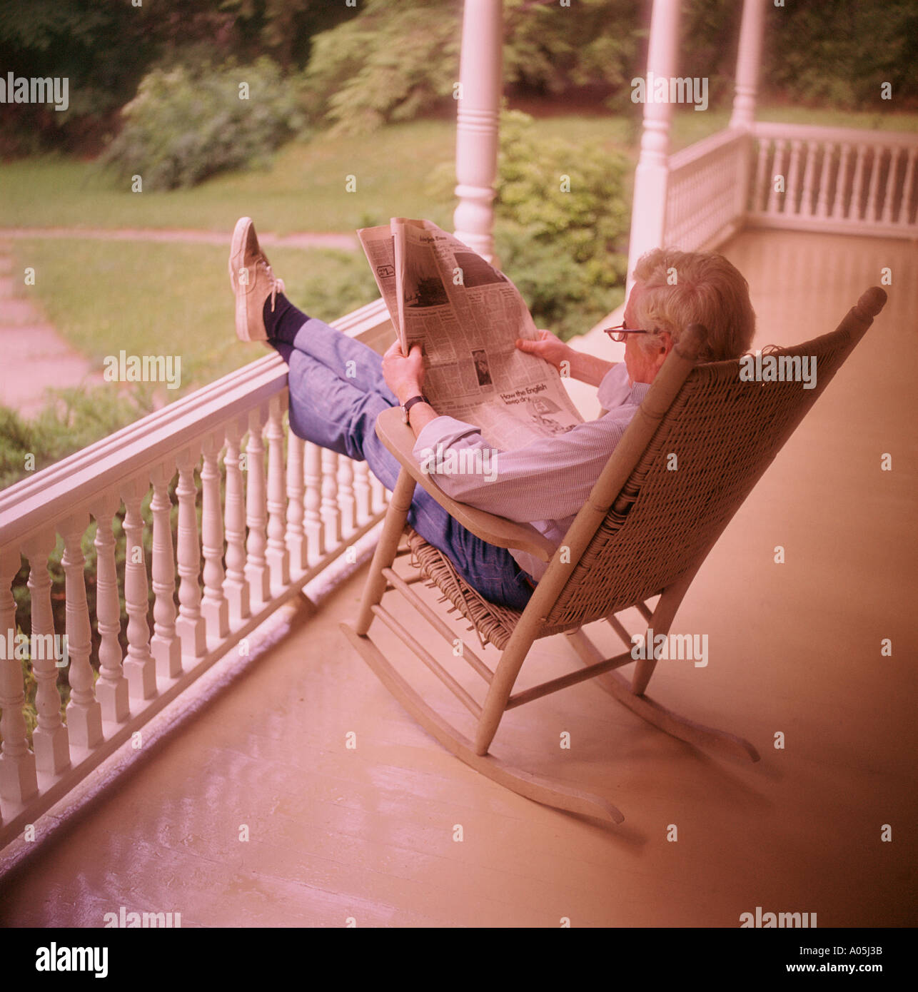 Mature white hair man sitting on a rocking chair on the front porch ...