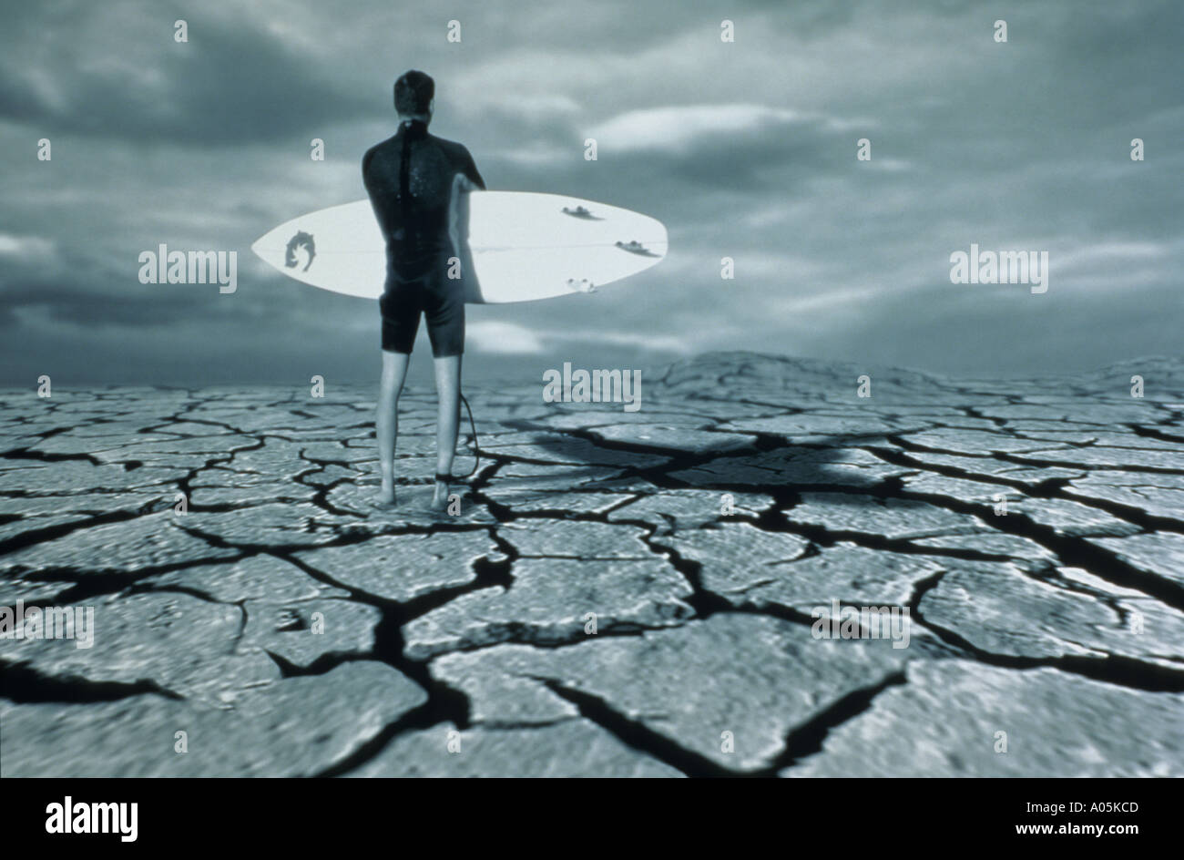 Conceptual image of a man holding his surfboard surveying a parched ...